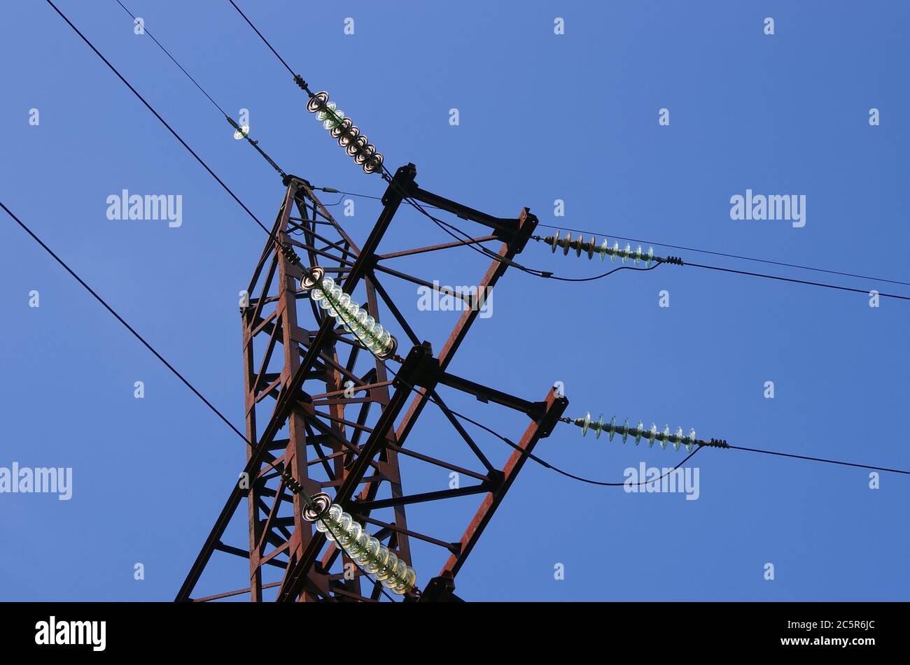 Electricity pylon with insulators and power lines. Blue sky background ...