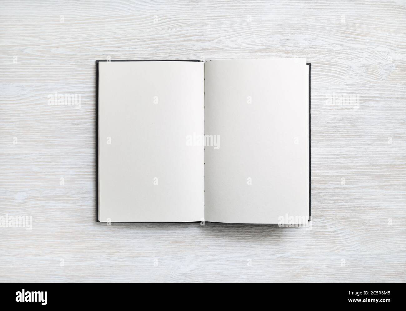 Open blank book on light wood table background. Space for text. Flat ...