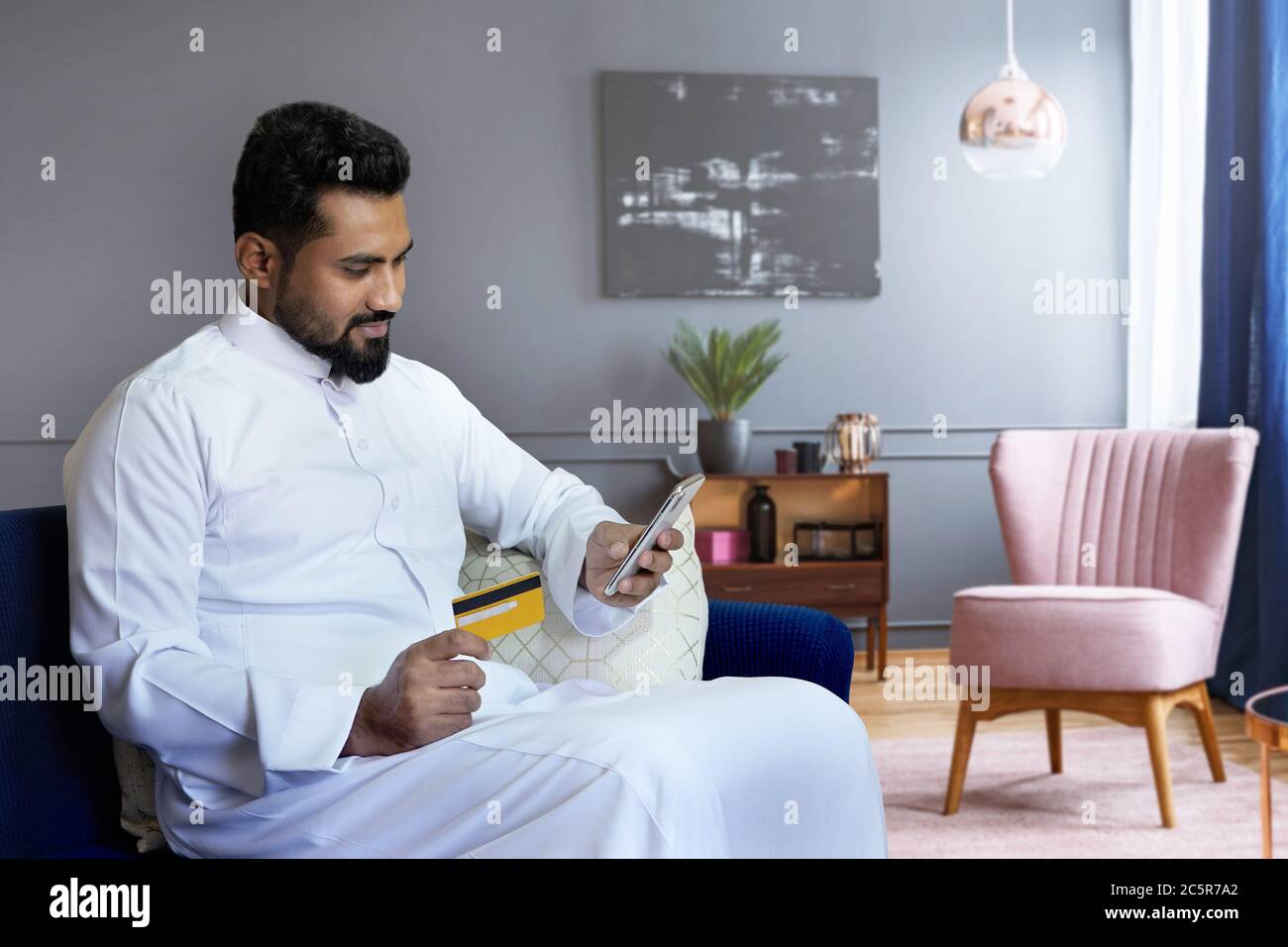 Saudi Arab Man doing online transaction using mobile phone while ...