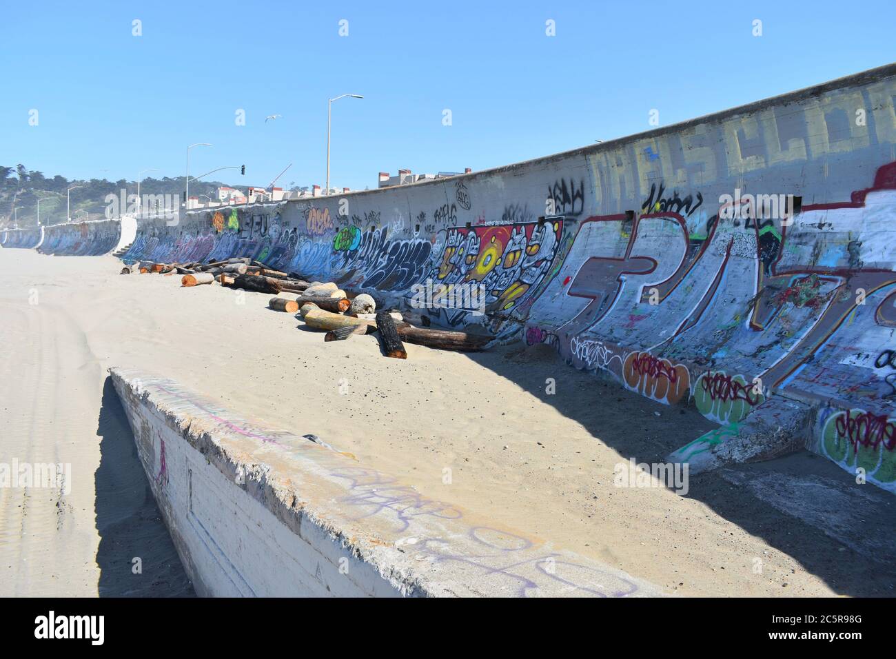 Colourful graffiti and driftwood along the sea wall on Ocean Beach, the Pacific Coast of San ...