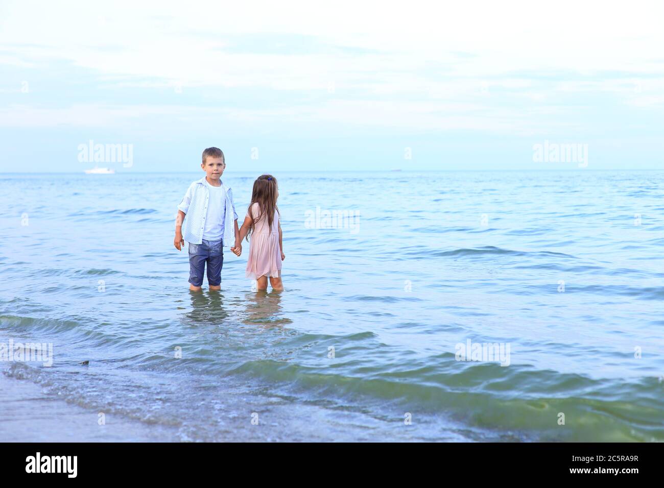 Two children run along the sea near the shore Stock Photo - Alamy