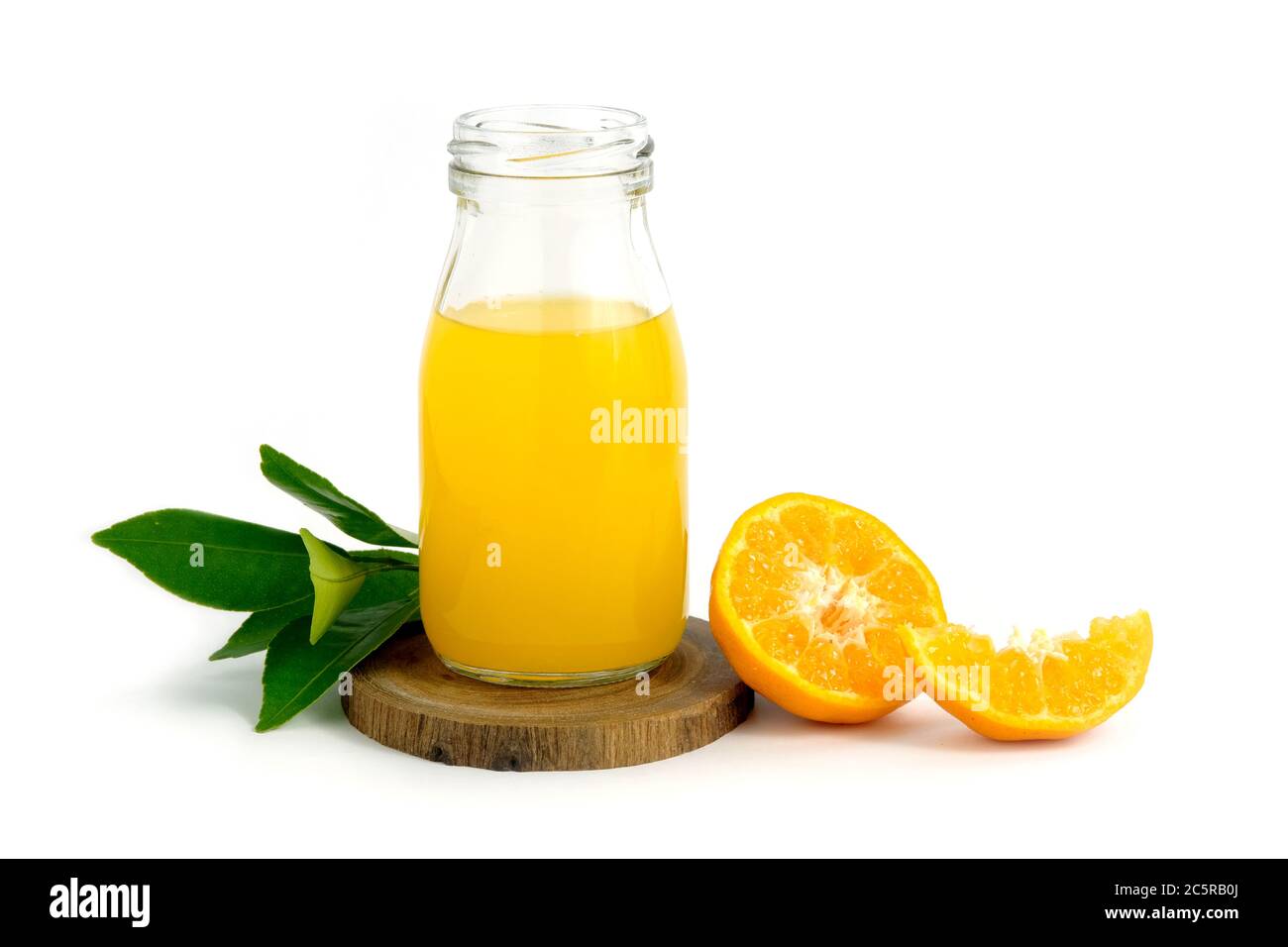 Fresh orange juice above wood coaster, with raw, sliced orange fruit ...