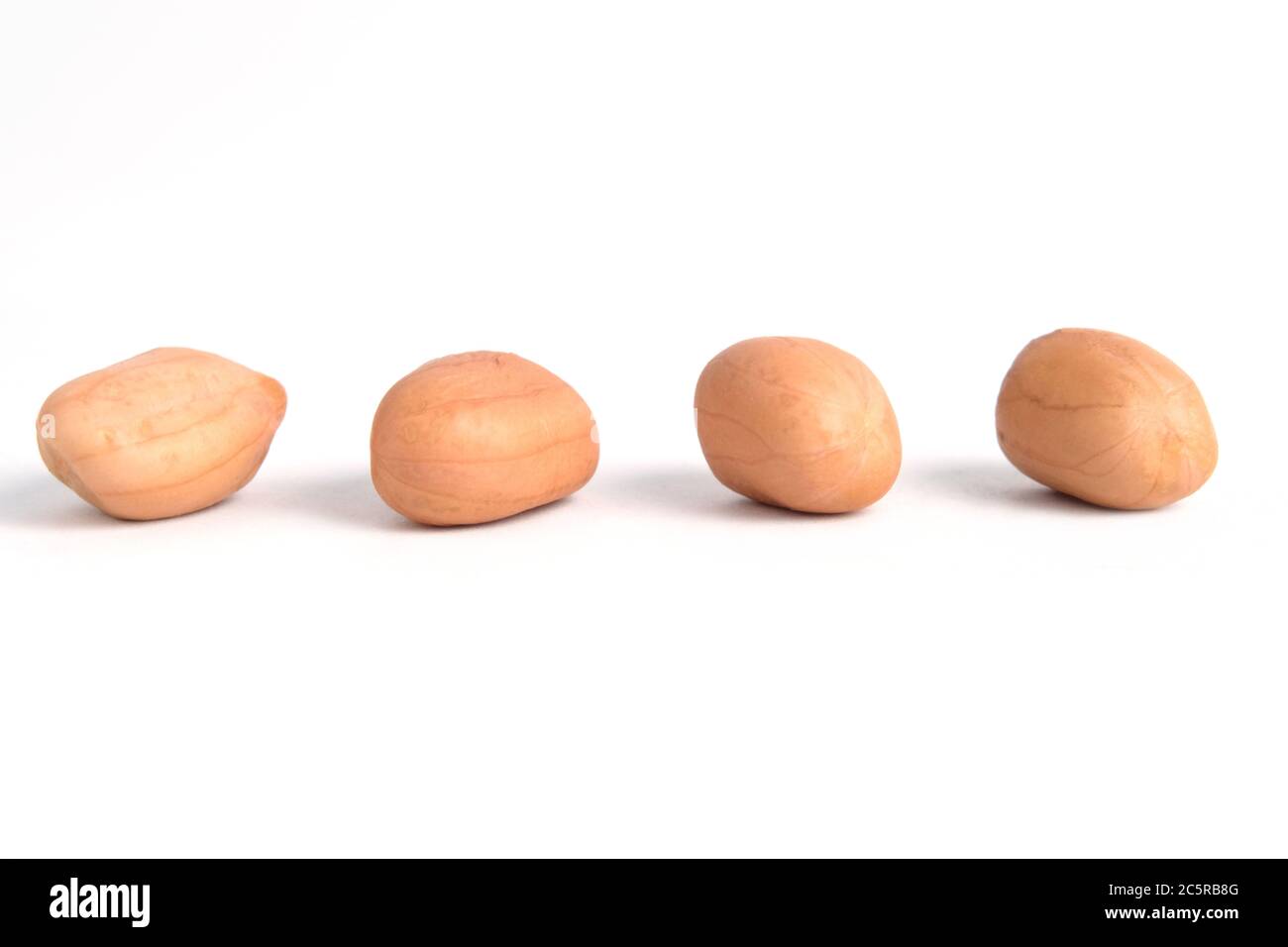 Closeup raw peanuts isolated on white background with studio lighting ...