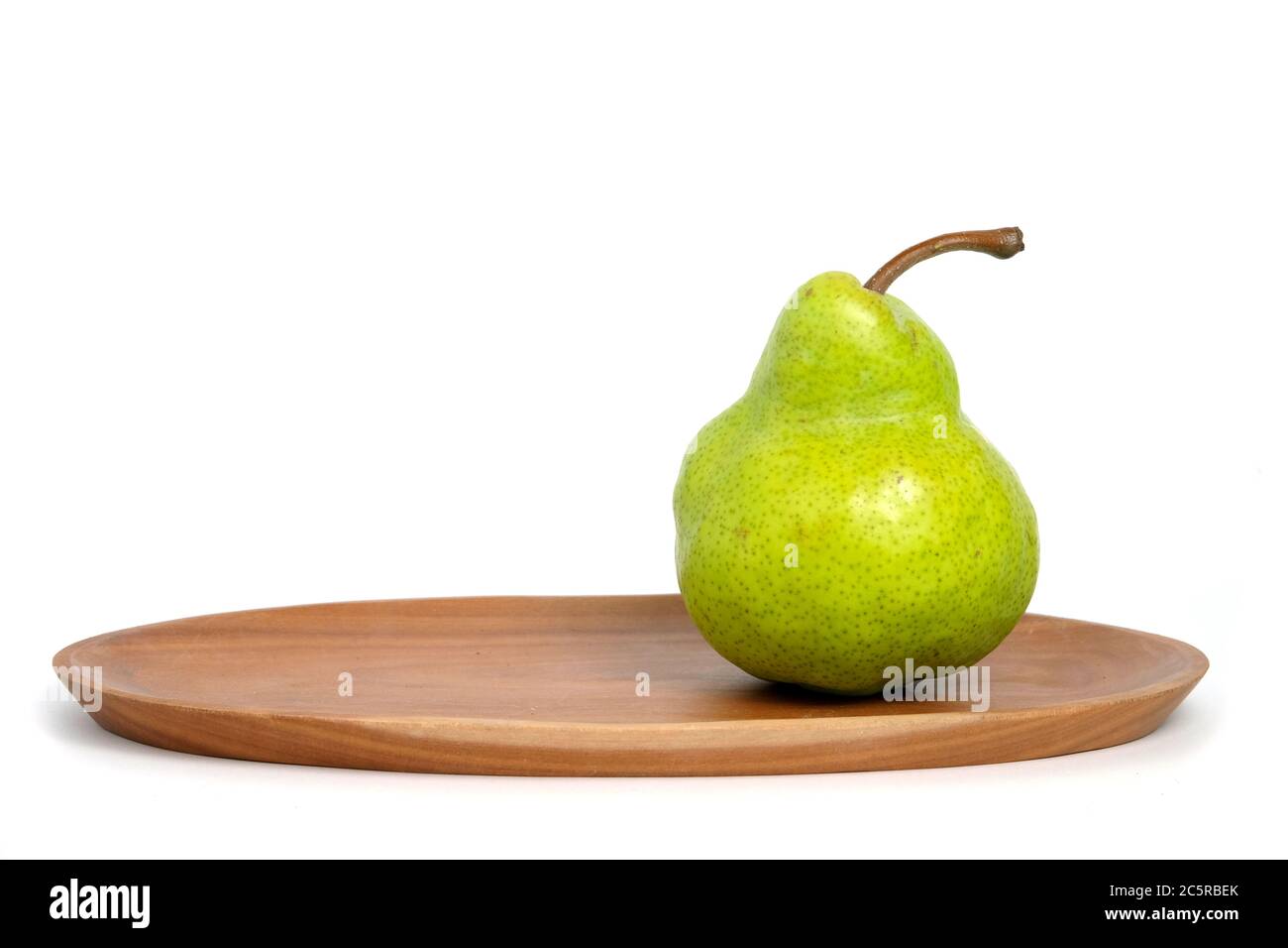 Single fresh Packham pears fruit above oval wooden plate isolated on ...