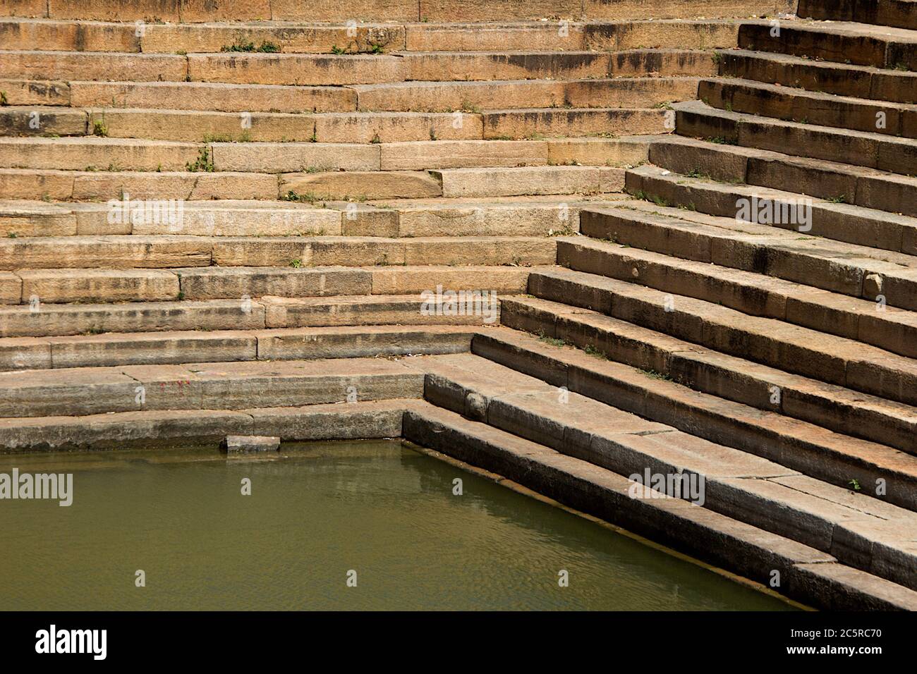 Horizontal and diagonal pattern of stone steps at pond in Melukote ...
