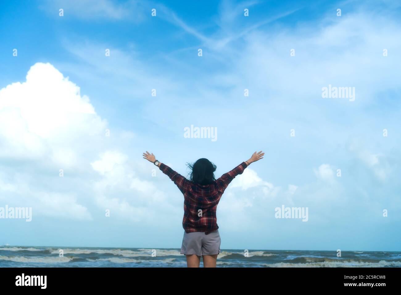 Woman rise hands up to sky freedom concept with blue sky and summer ...