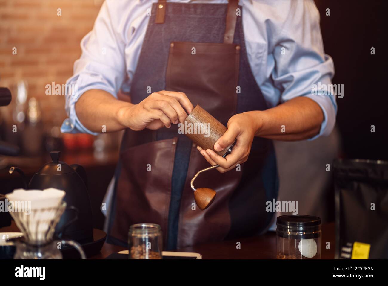 the barista hands on manual grinder coffee for grinding coffee beans at ...
