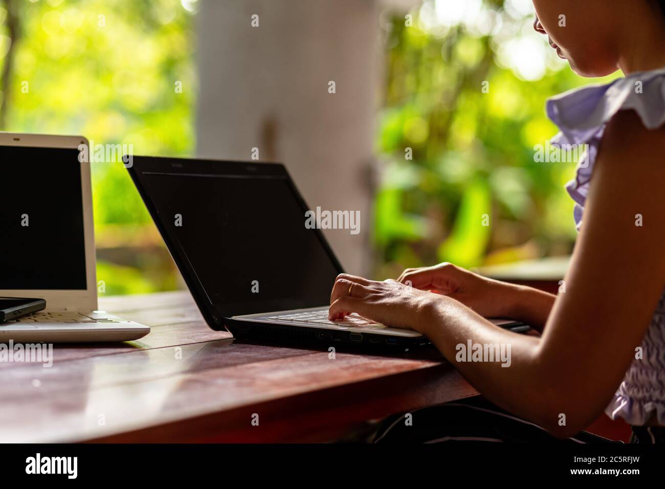 Women typing and working on laptop. computer on wood table at park ...