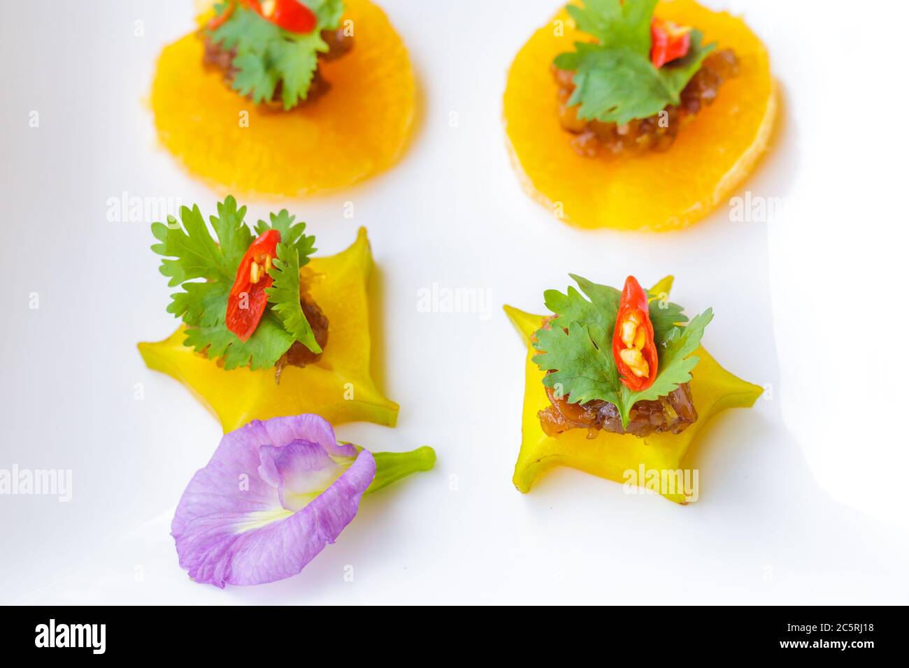 Thai Dessert name is " MA HOR " on the dish and they are on the table ...