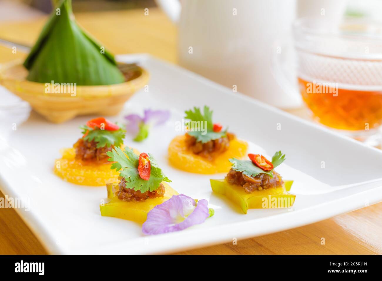 Thai Dessert name is " MA HOR " on the dish and they are on the table ...