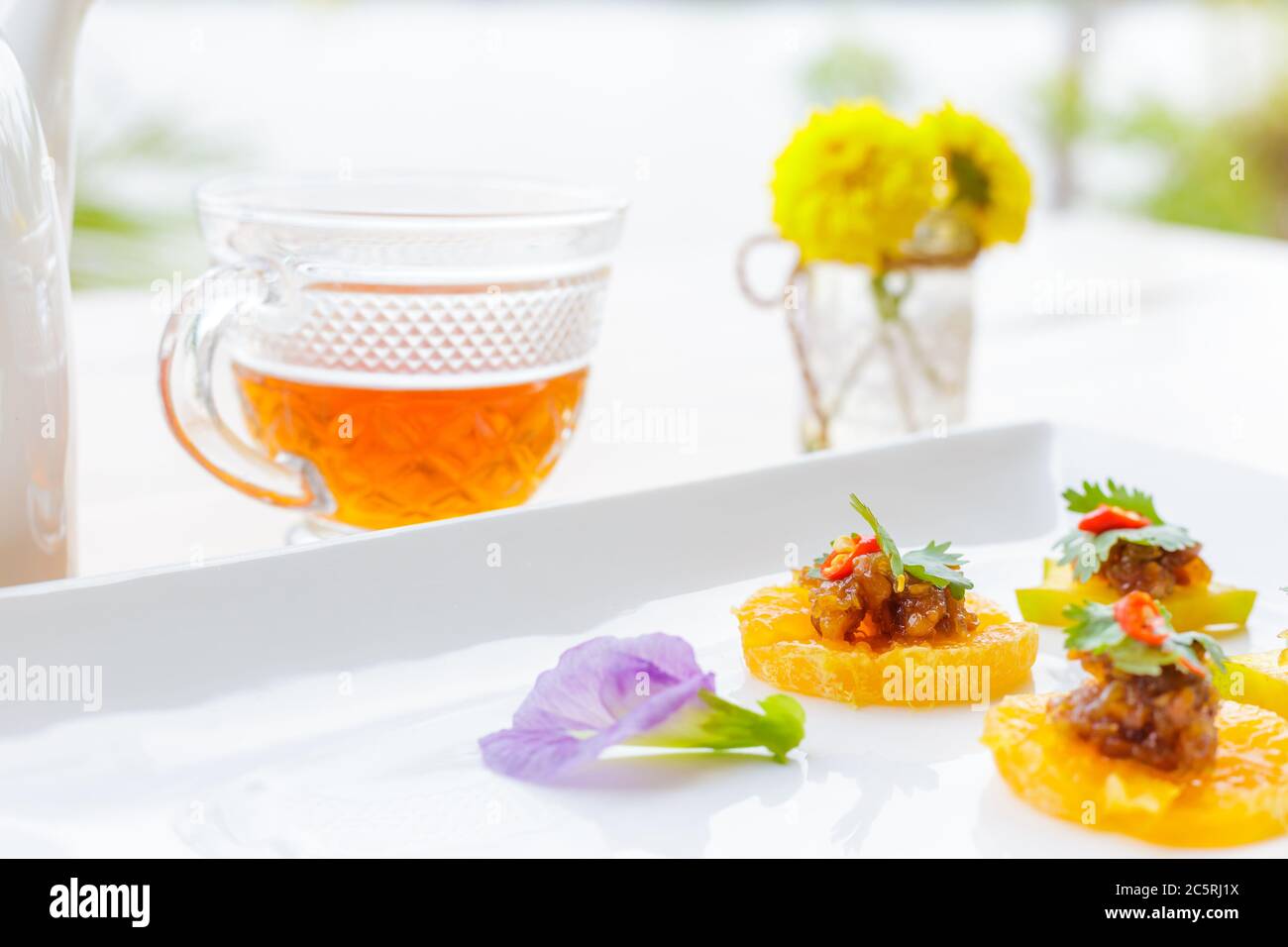 Thai Dessert name is " MA HOR " on the dish and they are on the table ...