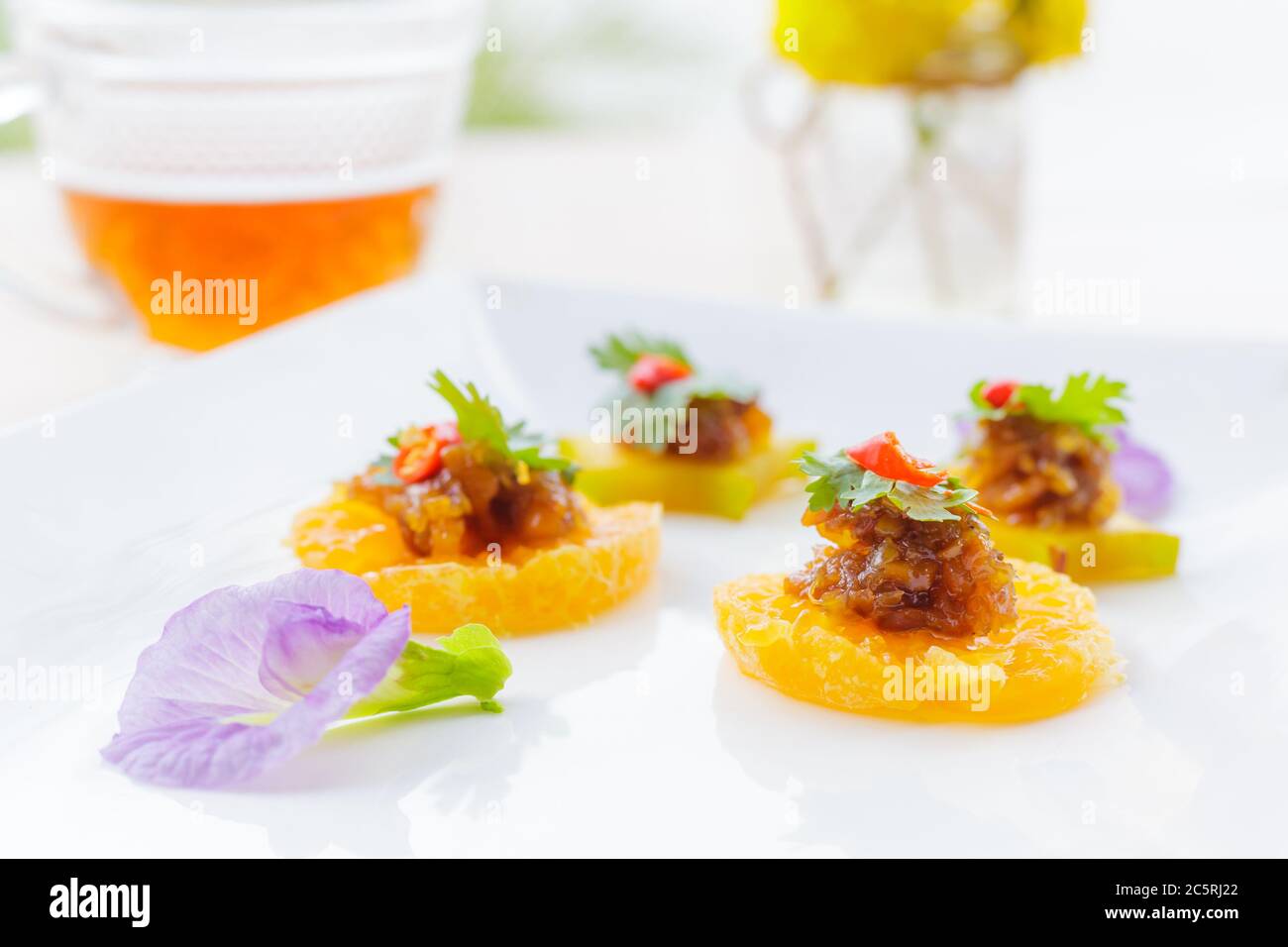 Thai Dessert name is " MA HOR " on the dish and they are on the table ...