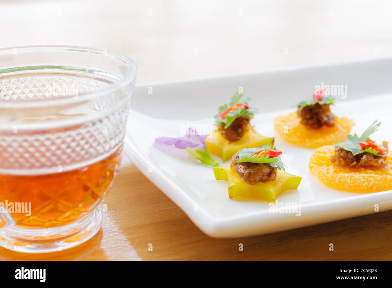 Thai Dessert name is " MA HOR " on the dish and they are on the table ...