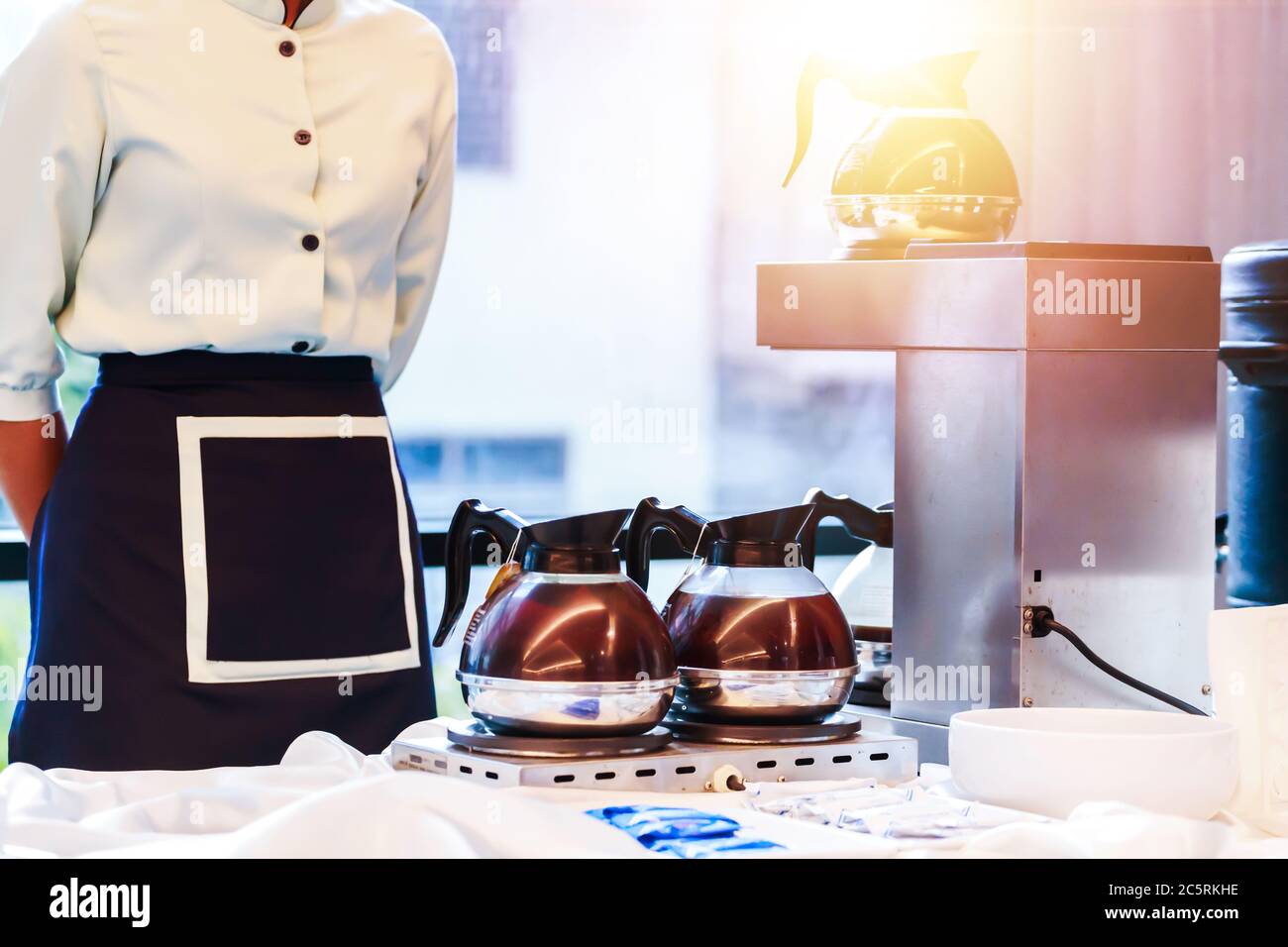 Waitress stand near coffee mug in gas stove and coffee machine Stock ...