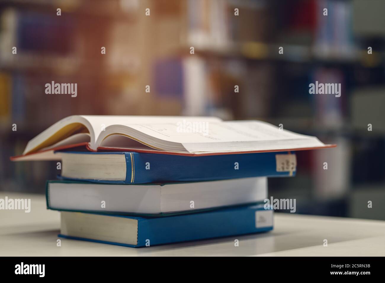 Open book on stack of books in library at school, university, college ...