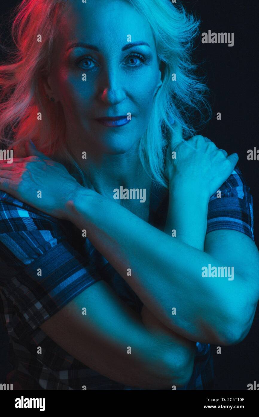 Portrait old woman in colorful bright lights. blue and red crossed his ...