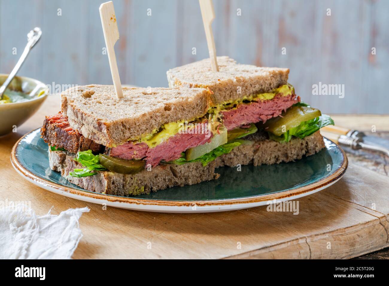 Salt beef sandwich with pickled cucumber and mustard tartar sauce cut ...
