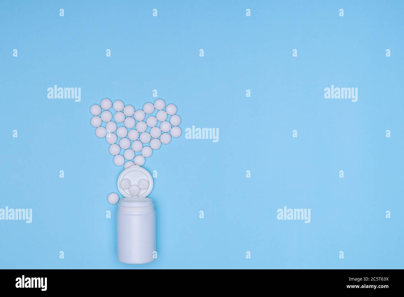 Medicines white, round heart shaped pills isolated on blue background ...