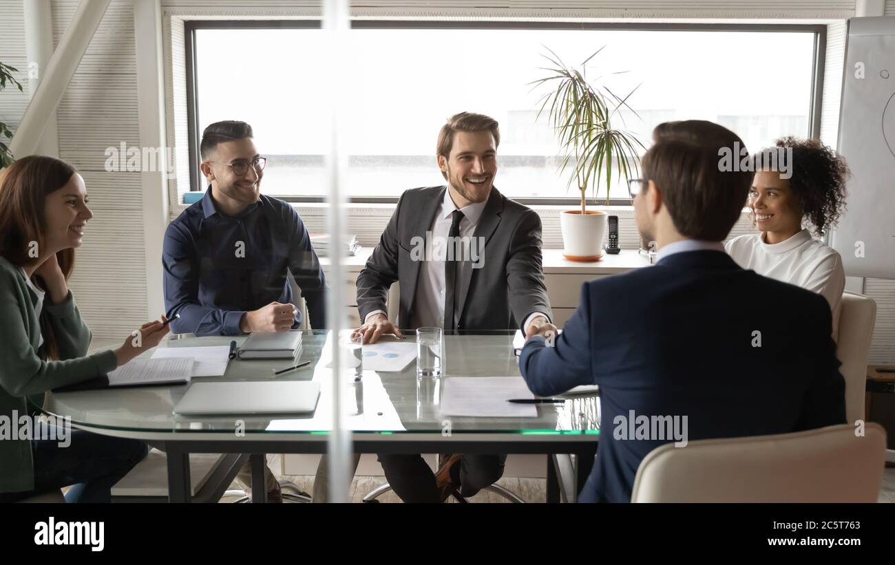 Smiling businessmen handshake closing deal at meeting Stock Photo - Alamy