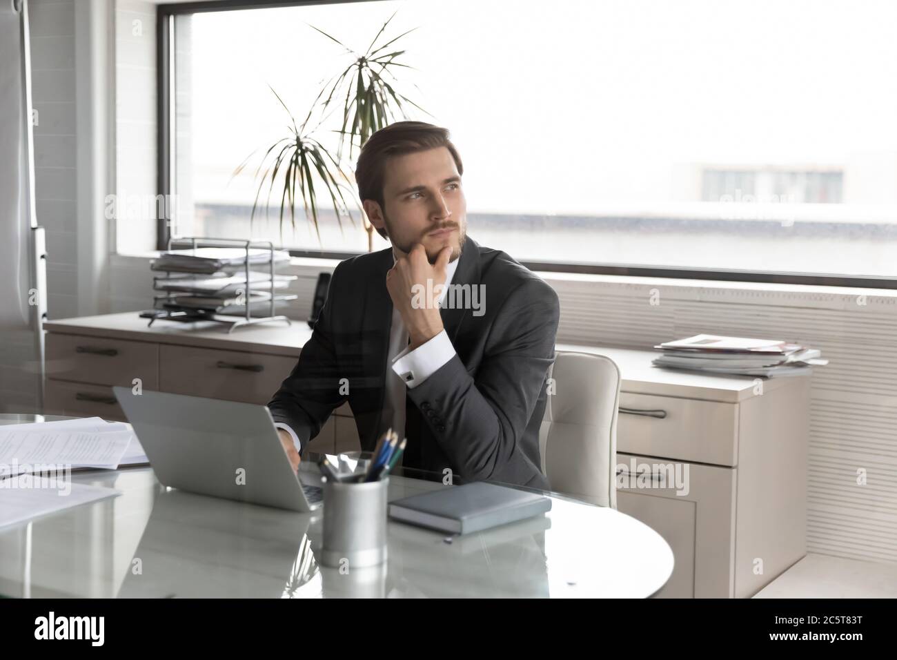 Thoughtful male CEO work on laptop making decision Stock Photo - Alamy