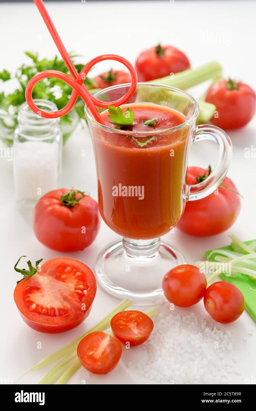 Tomato juice in glass with celery, cherry tomato, white wood background ...