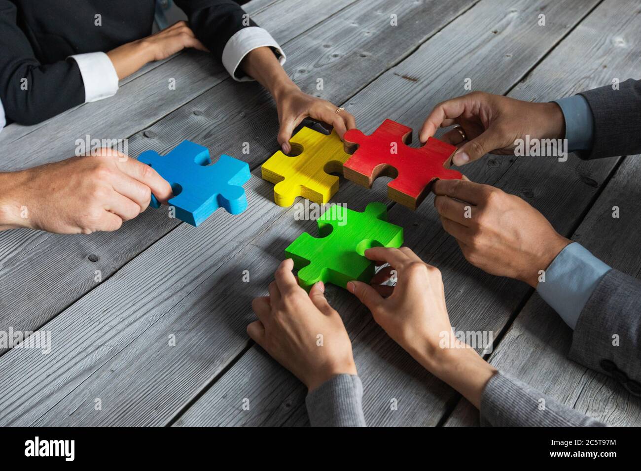 Business people team sitting around meeting table and assembling color ...