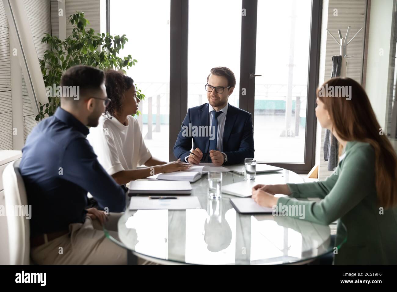 Multiethnic colleagues talk discuss business ideas at team office ...