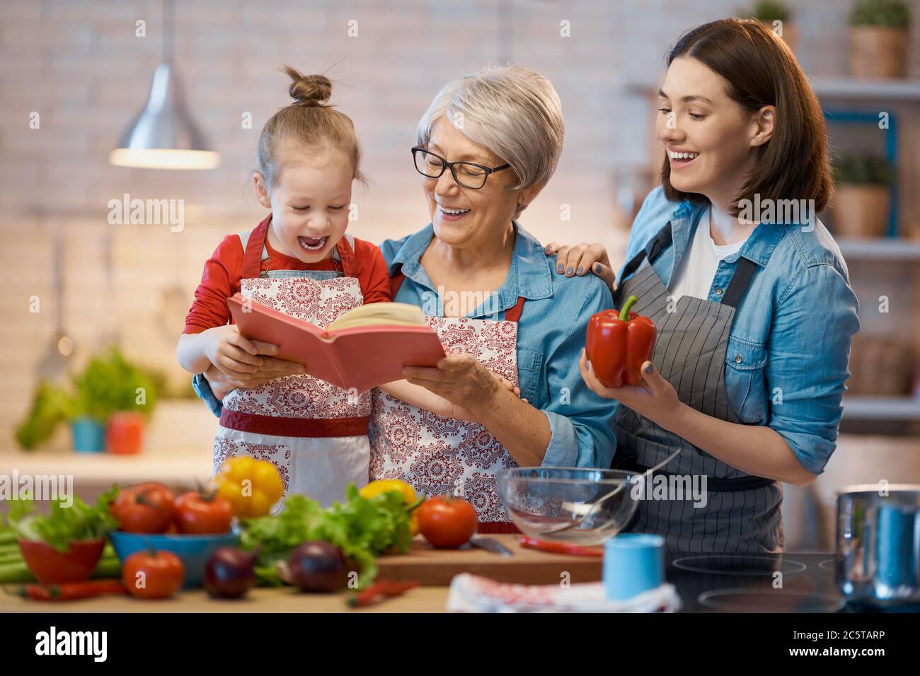 Healthy food at home. Happy family in the kitchen. Grandma, mother and ...