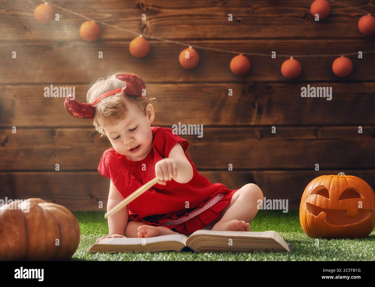 Happy Halloween! Cute cheerful little devil with a magic wand ...