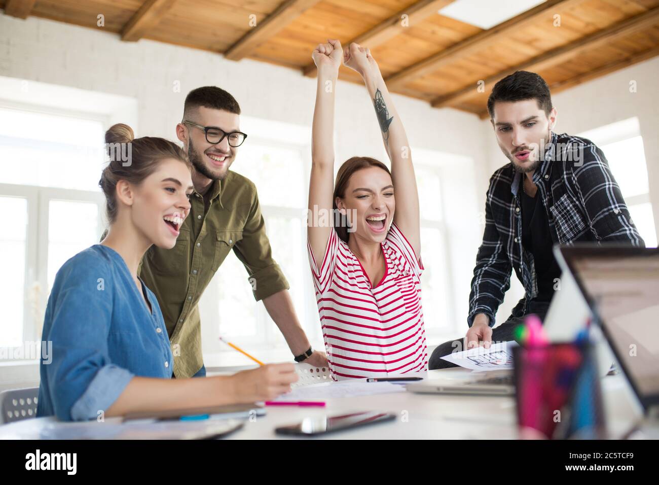 Group of cheerful business men and women happily working together in ...
