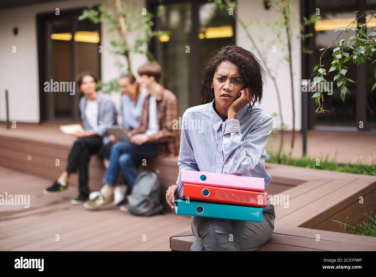 Photo of upset lady sitting on bench with colorful folders and sadly ...