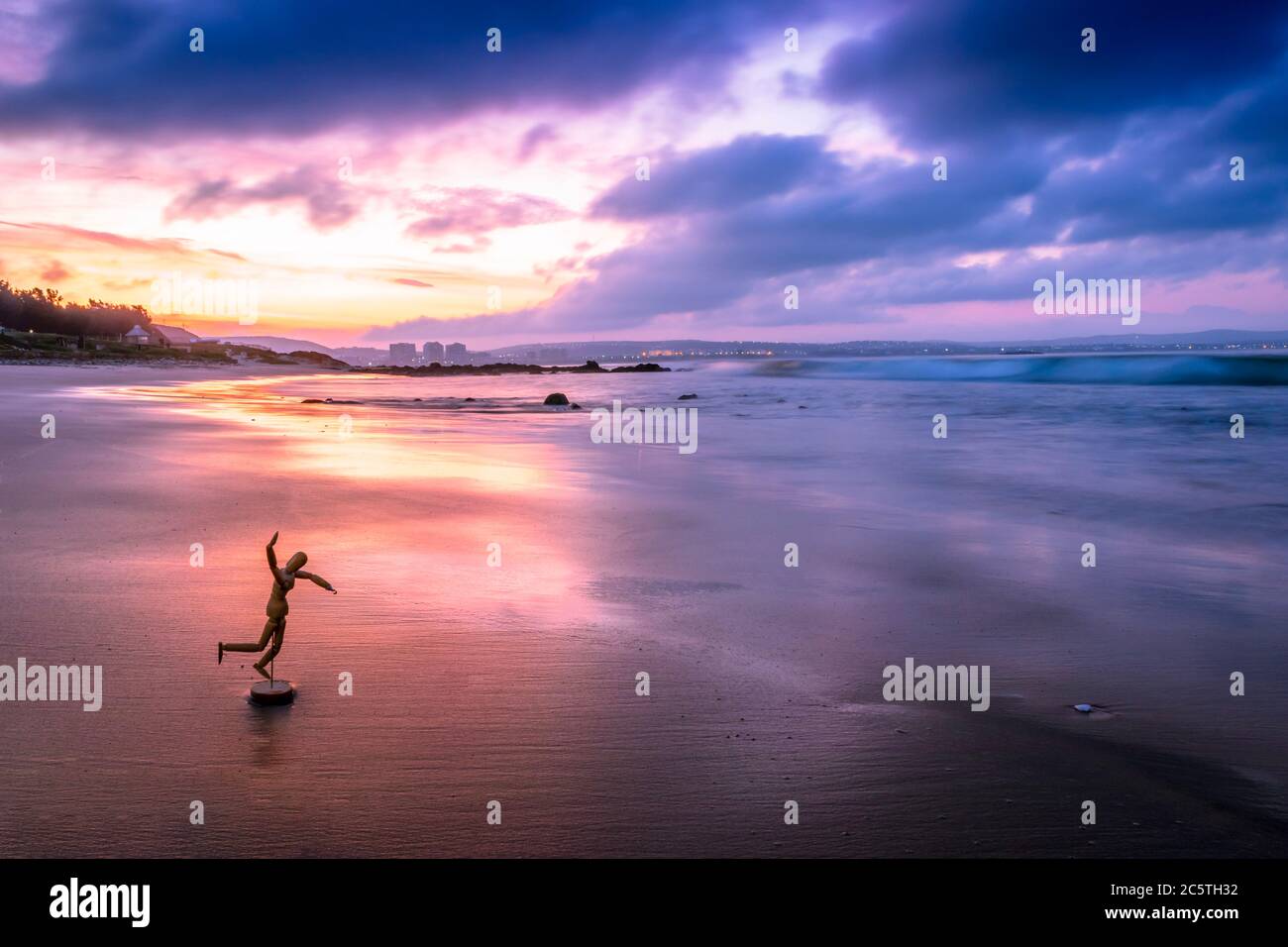 Wooden Human Manikin posing on beach with a view of a beautiful cloudy ...