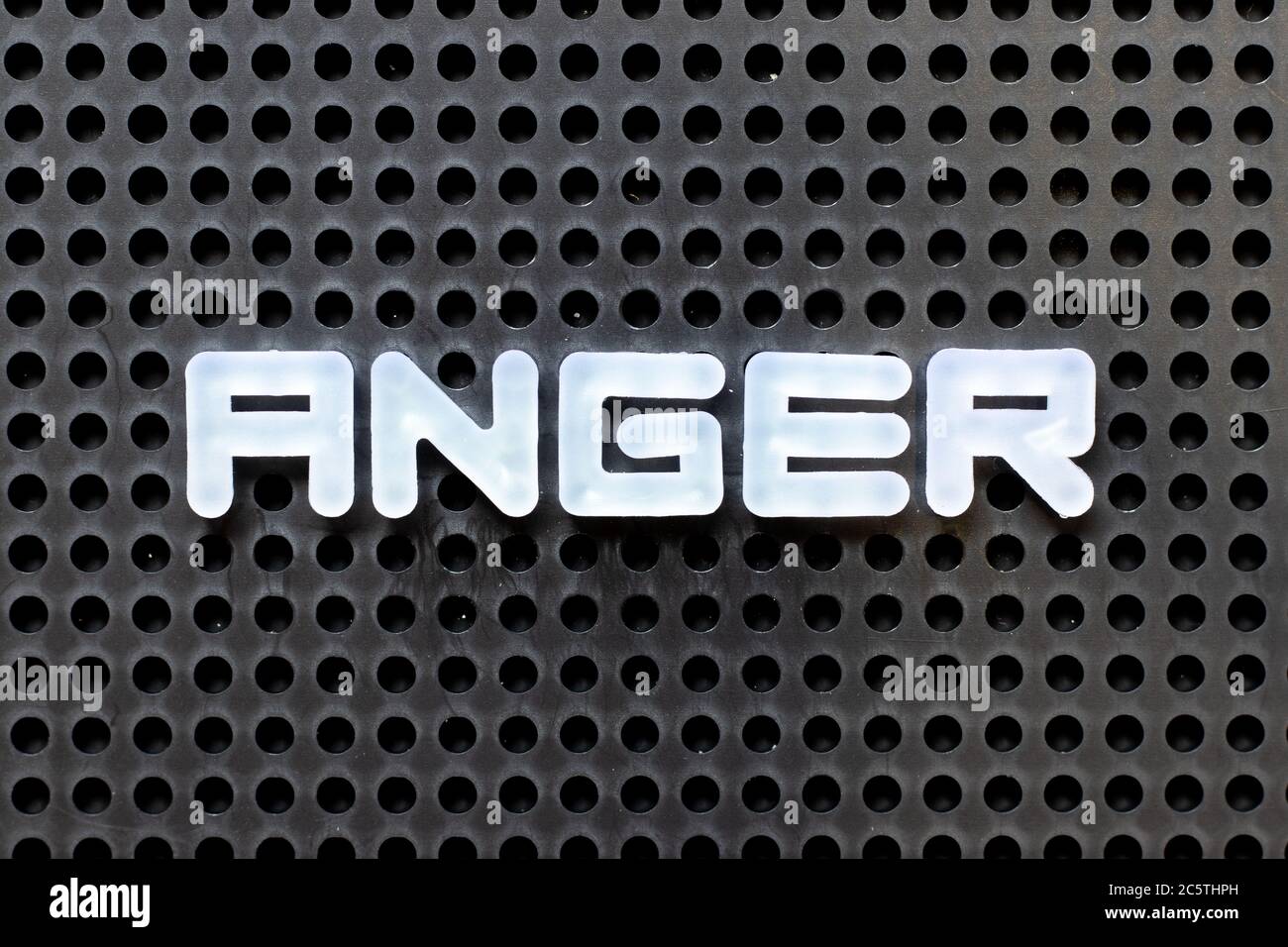 White color alphabet with word anger on black pegboard background Stock ...
