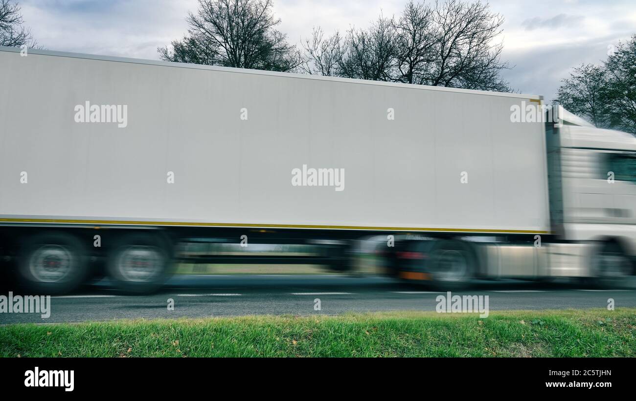 Heavy goods vehicle on highway. Car is blurred to make it impossible to ...