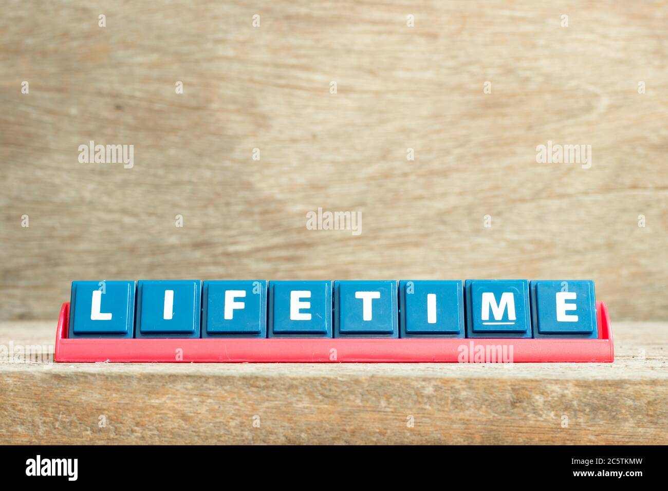 Tile letter on red rack in word lifetime on wood background Stock Photo ...