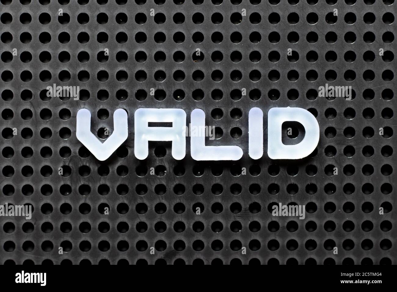 White color alphabet with word valid on black pegboard background Stock ...