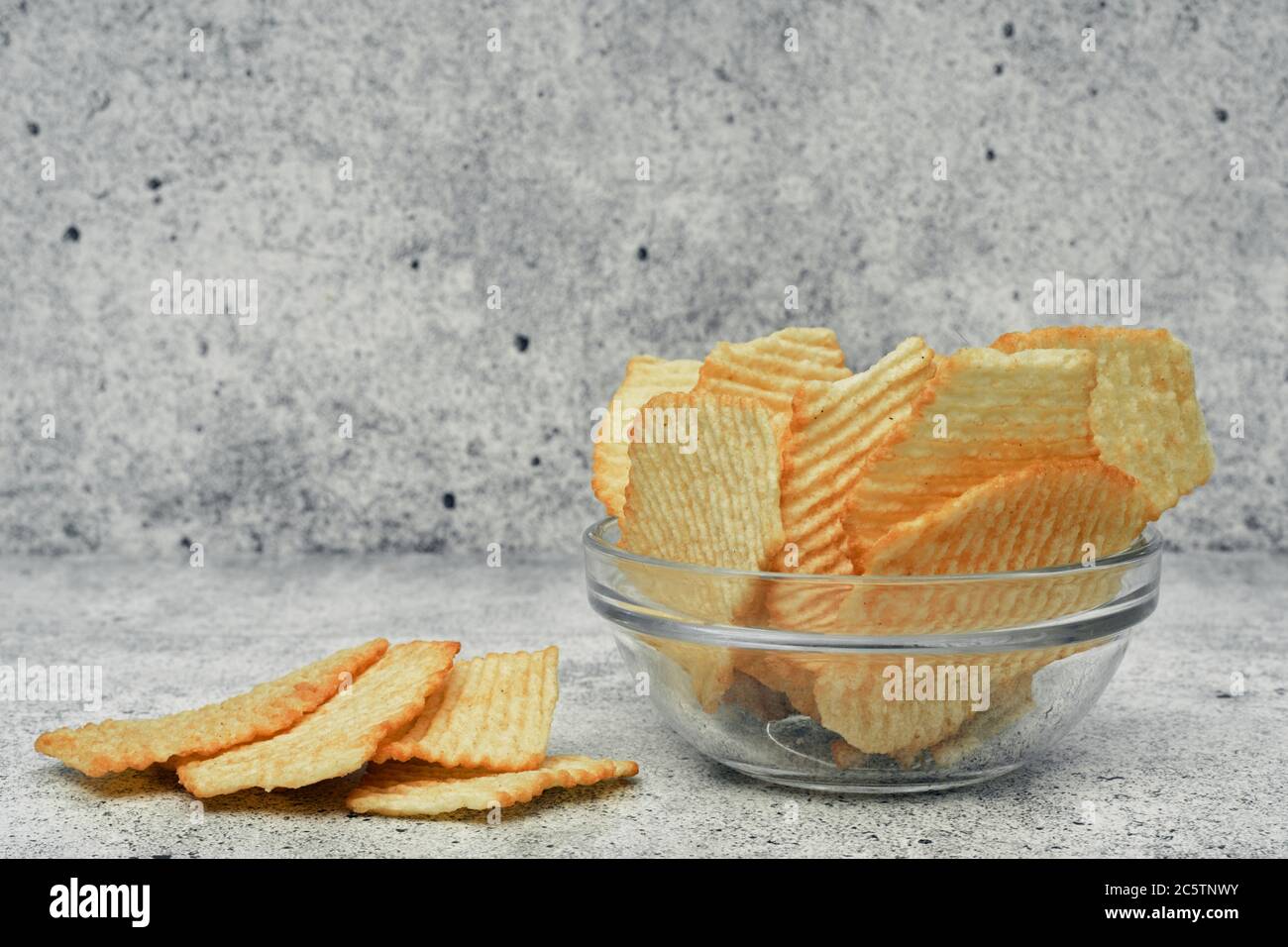 Corrugated potato chips in a slack transparent plate. Snack, junk food ...