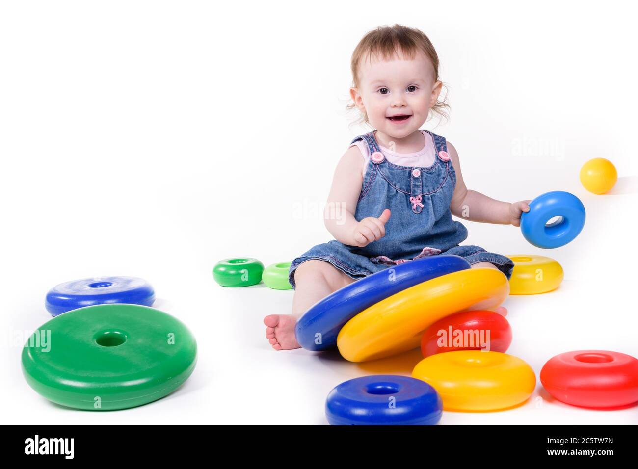 Cute little girl, enthusiastically playing in colorful pyramid ...