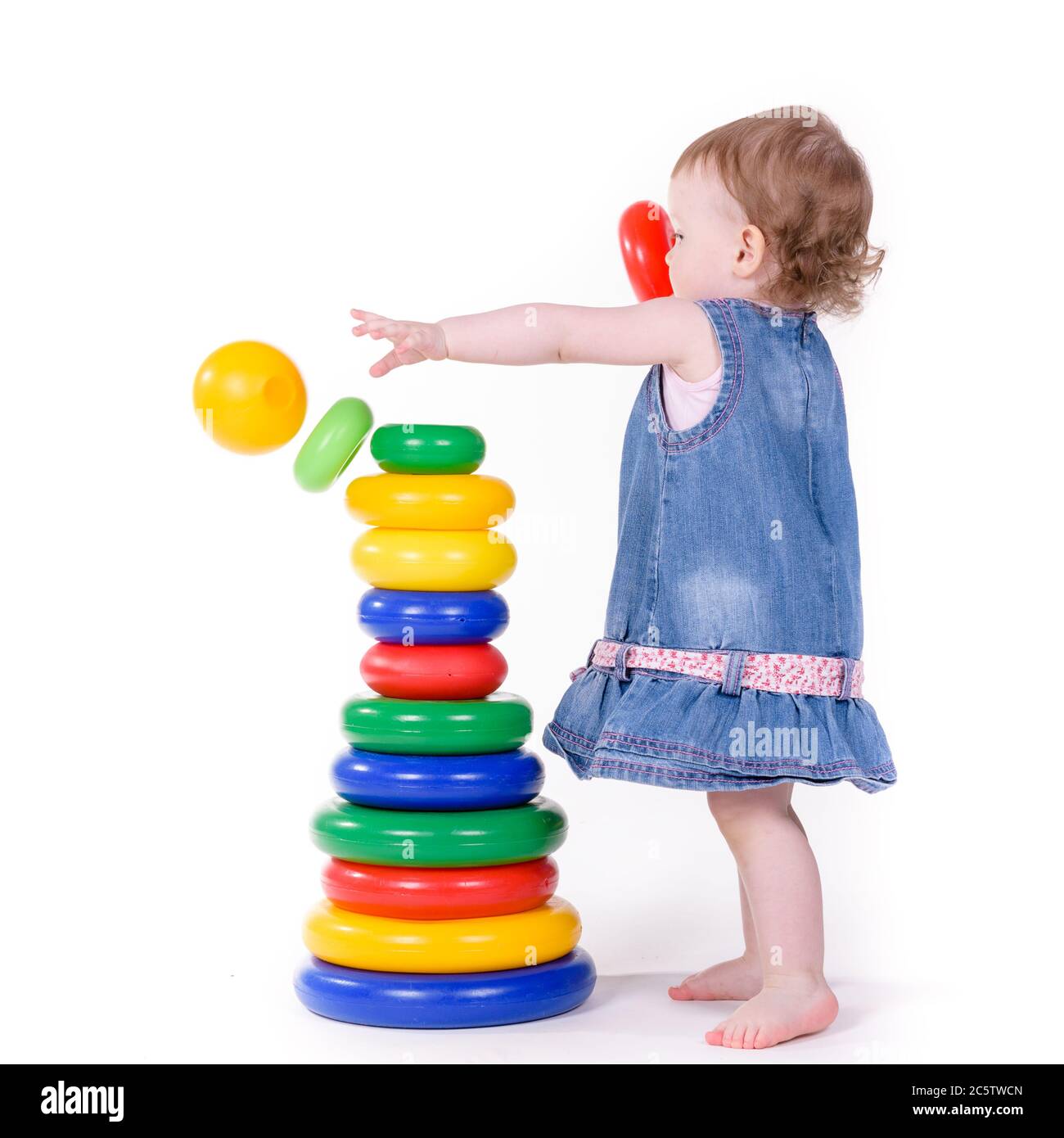 Cute little girl, enthusiastically playing in colorful pyramid ...