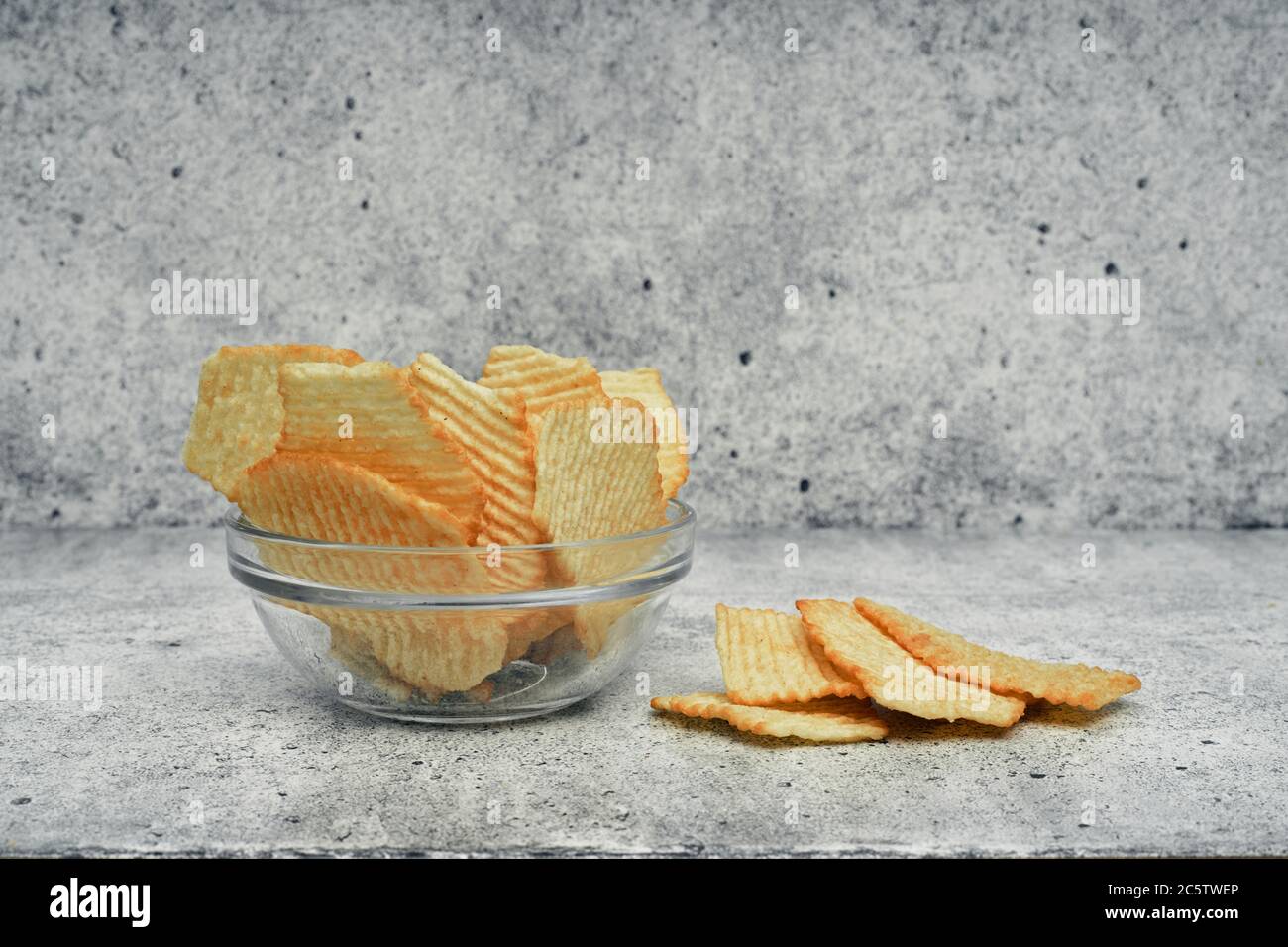 Corrugated potato chips in a slack transparent plate. Snack, junk food ...