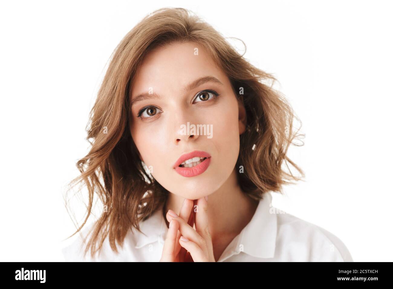 Portrait of young beautiful woman dreamily looking in camera on white ...