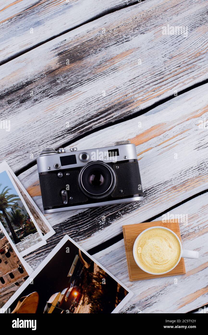 Cup of cappuccino and vintage photo camera with photos Stock Photo - Alamy