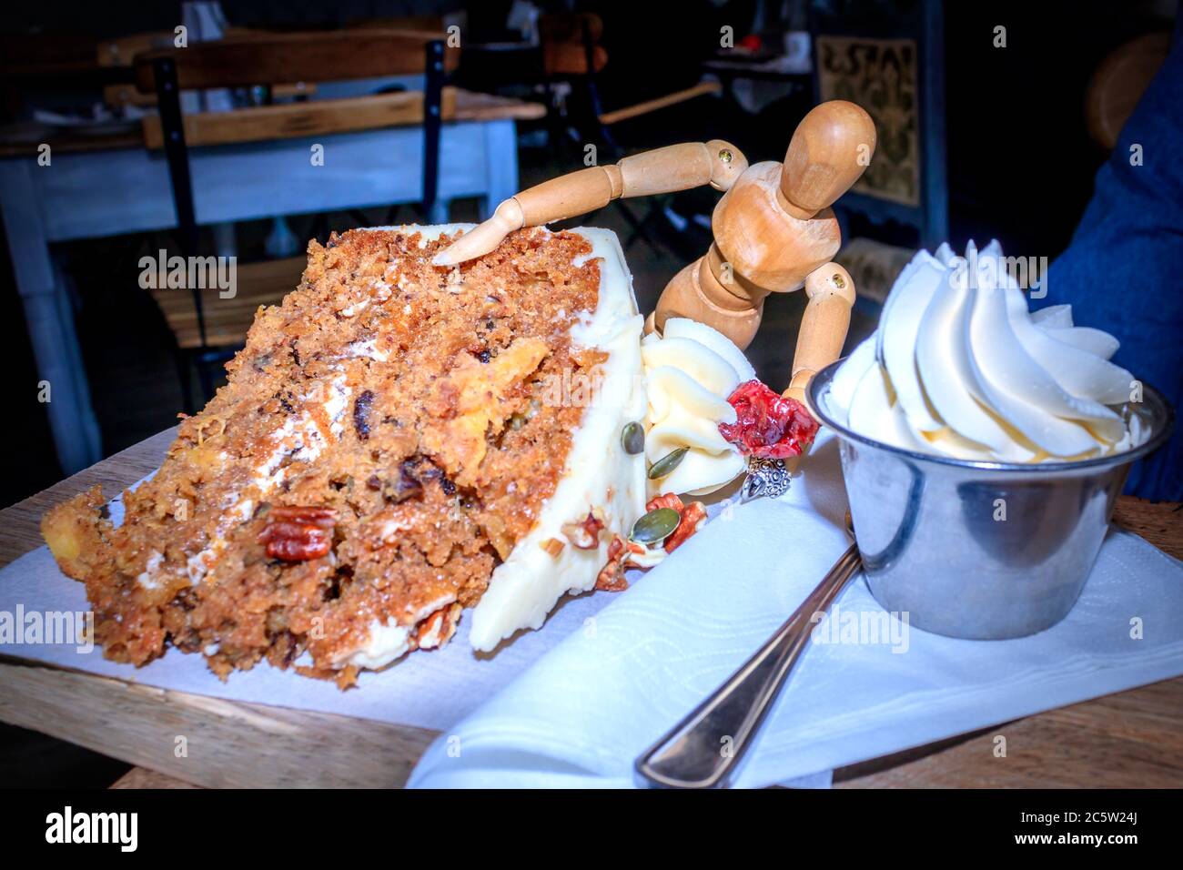 Wooden Human Manikin eating a delicious cake covered in icing, in a ...