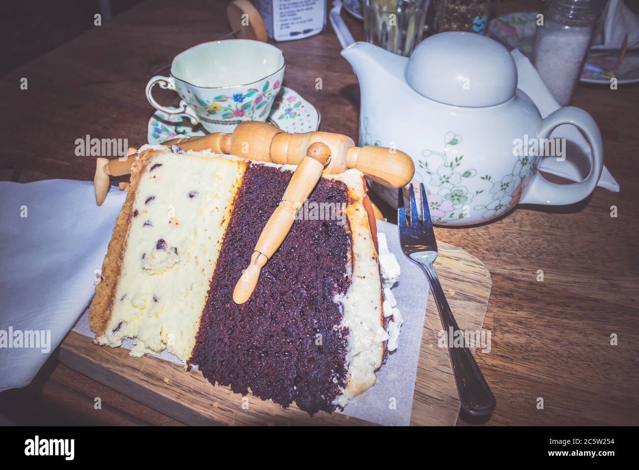 Wooden Human Manikin eating a delicious cake covered in icing, in a ...