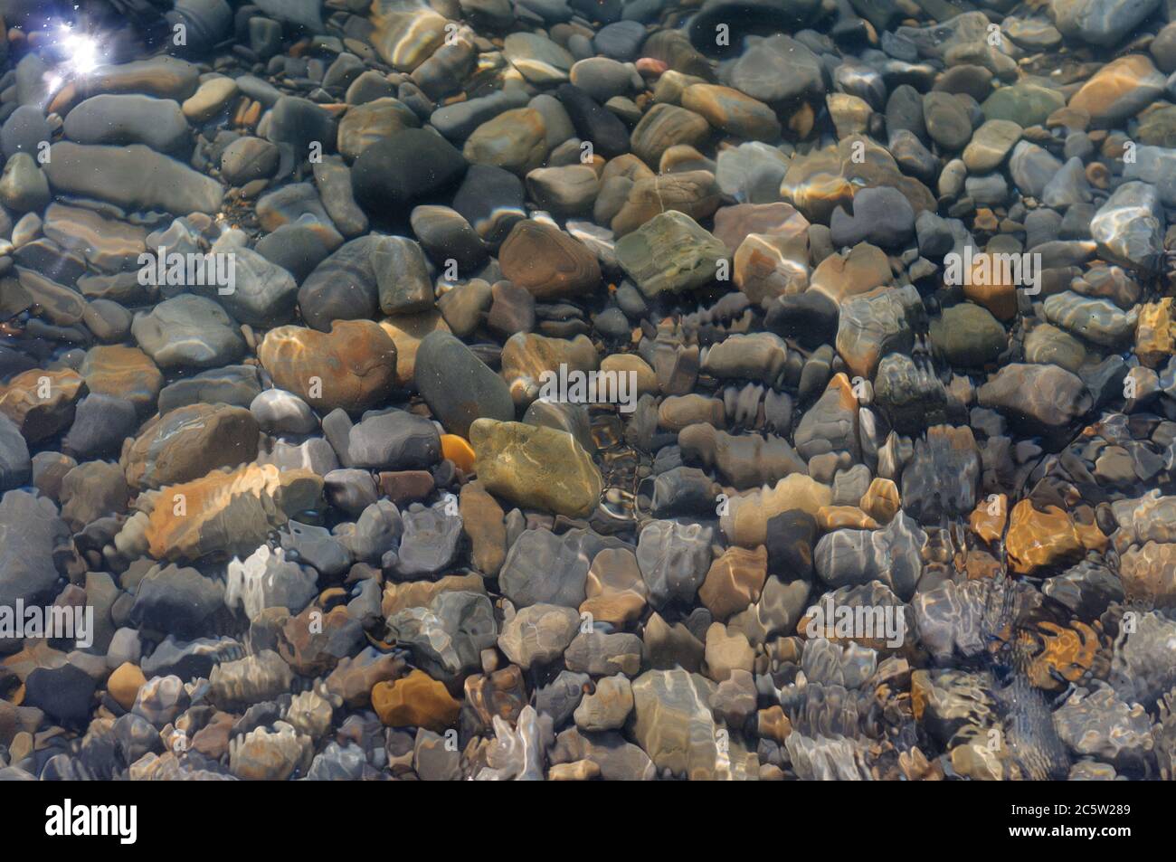 Stones lying in the water. Blue sea water splash. Background of sea ...