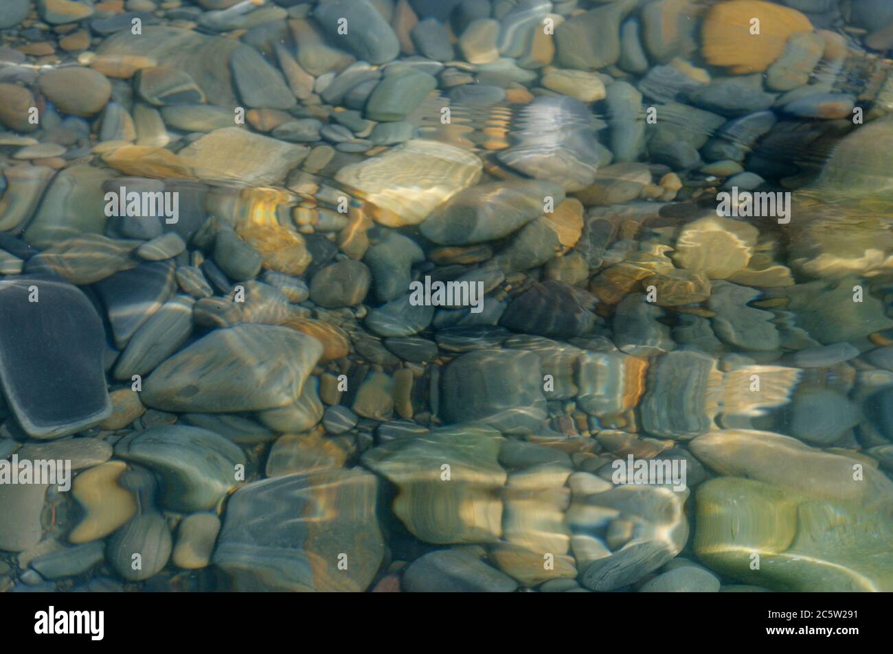 Stones in the water. Blue sea water splash. Background of sea water. A ...