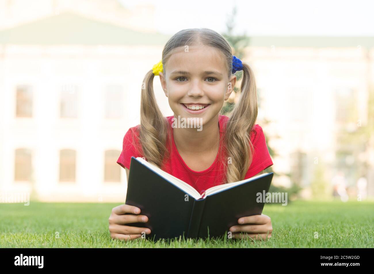 Open your imagination, read. Happy kid read book on green grass ...