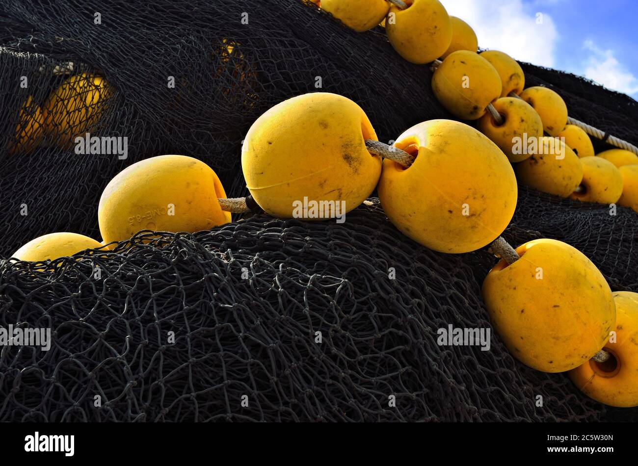 Black fishing net with orange corks Stock Photo - Alamy