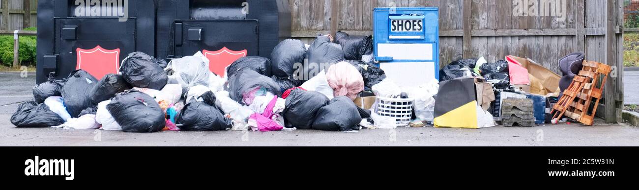 Clothes and shoes charity recycle container and black bin bags in a ...
