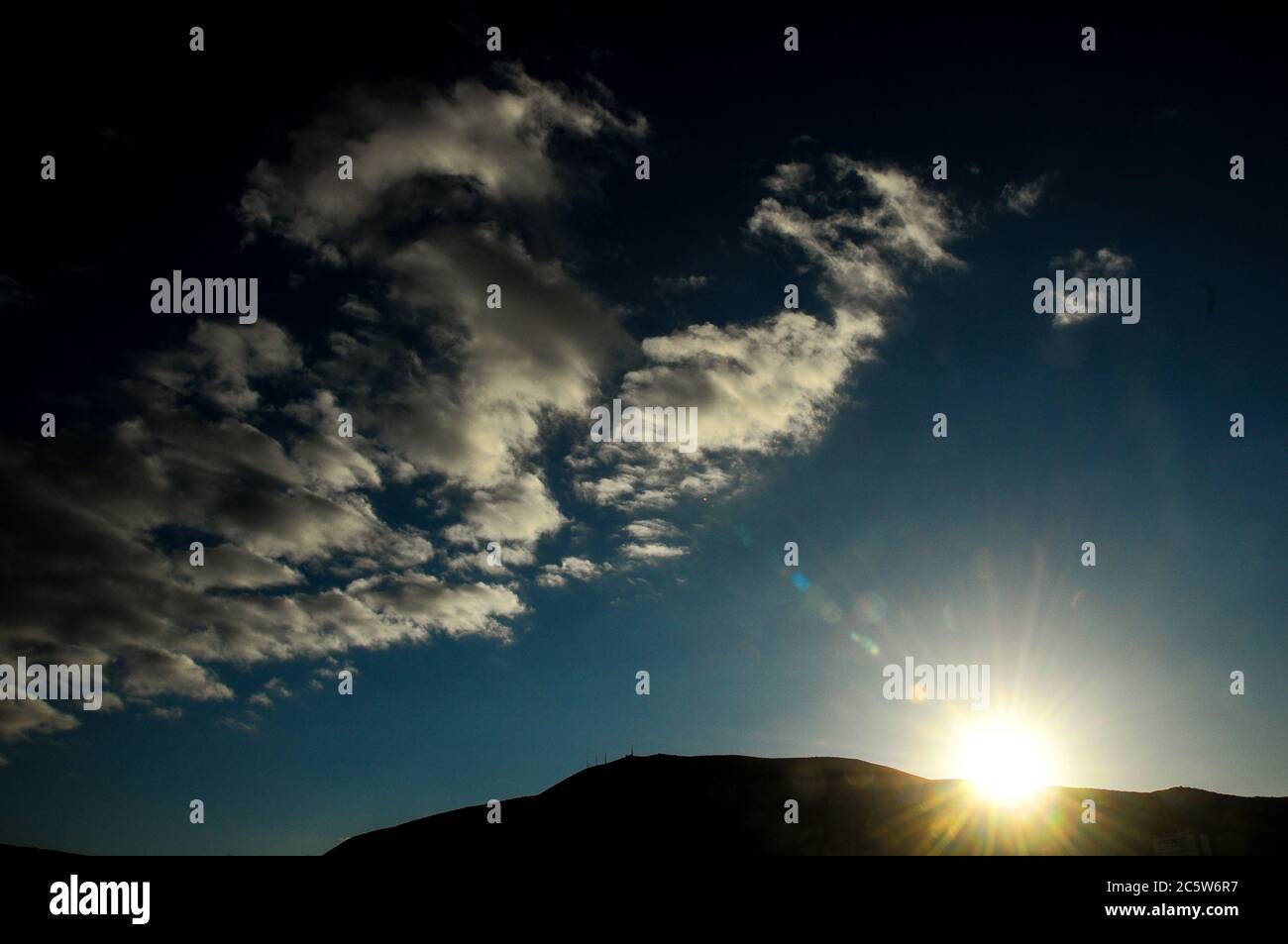 Dramatic Sunset Rays Behind Silhouette of a Mountain Stock Photo - Alamy